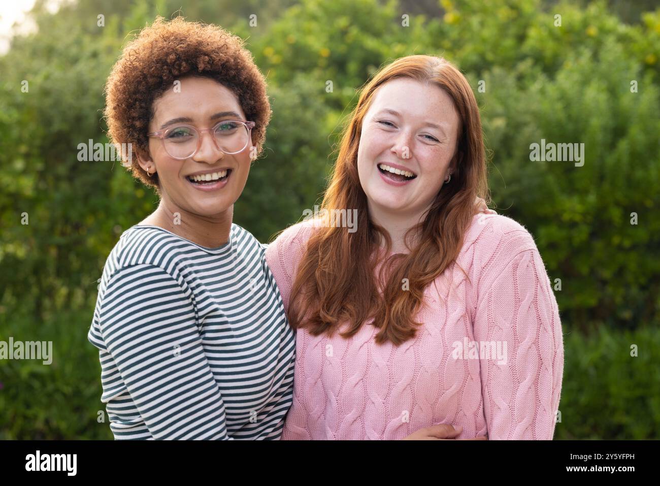 Standing together outdoors, smiling women friends enjoying time and ...