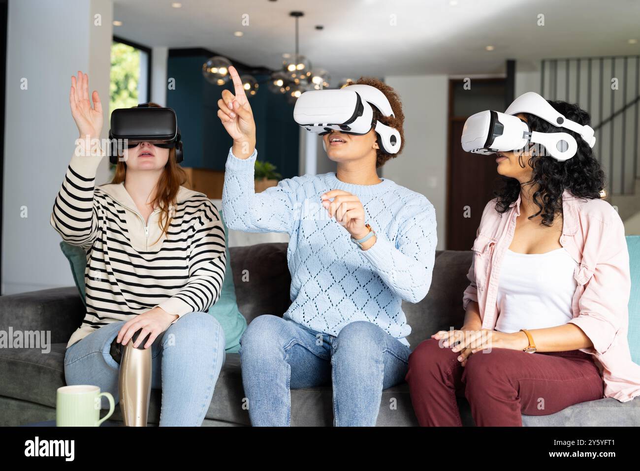 Using VR headsets, diverse women friends interacting with virtual ...