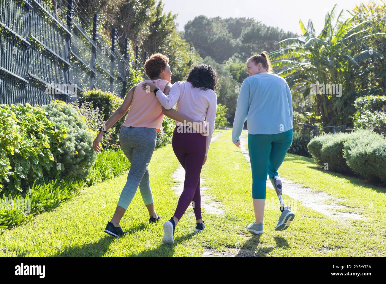 Walking together, diverse women friends enjoying outdoor stroll in lush ...