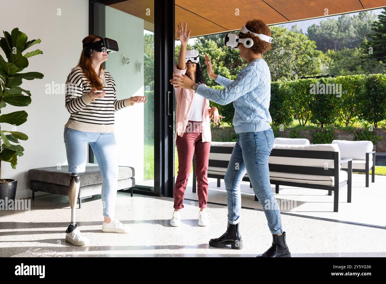 Using VR headsets, diverse women friends enjoying virtual reality experience together Stock ...