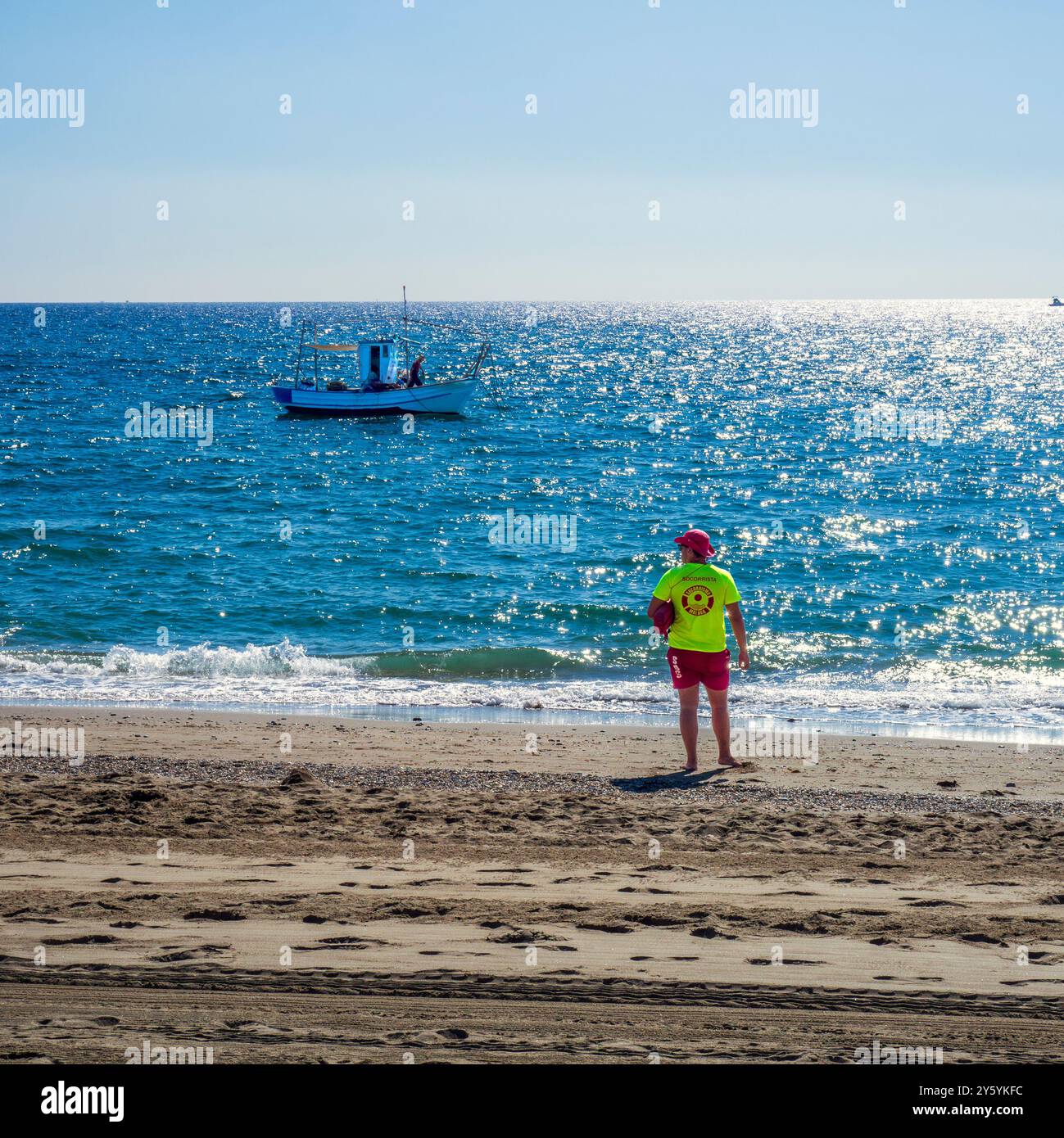 Lifeguard on the beach with a fishing boat in the background on the ...
