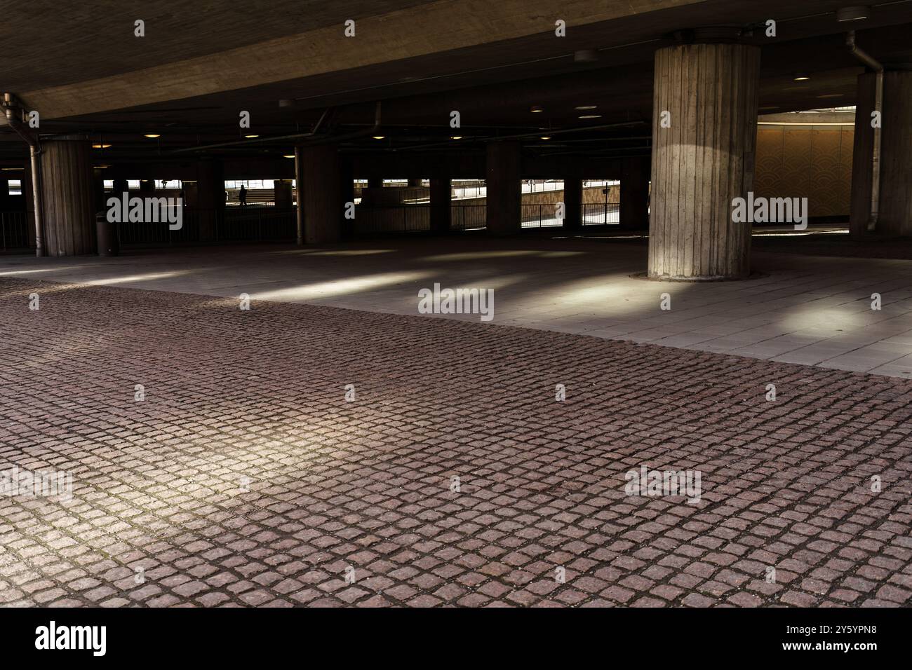 Cobblestone pavement underneath a concrete bridge structure Stock Photo ...