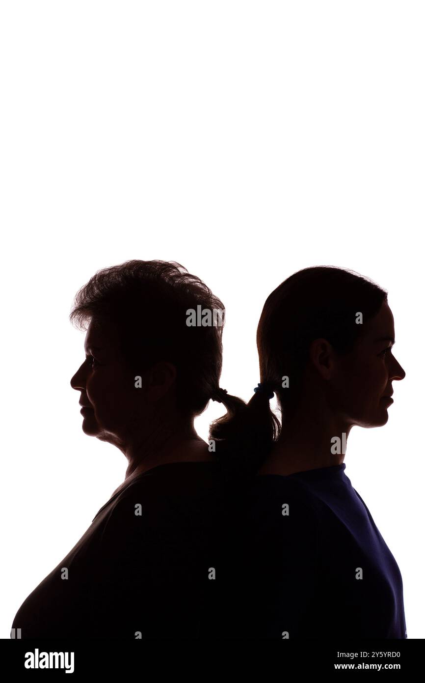 Dark silhouette of an elderly woman, a pensioner opposite a young woman ...