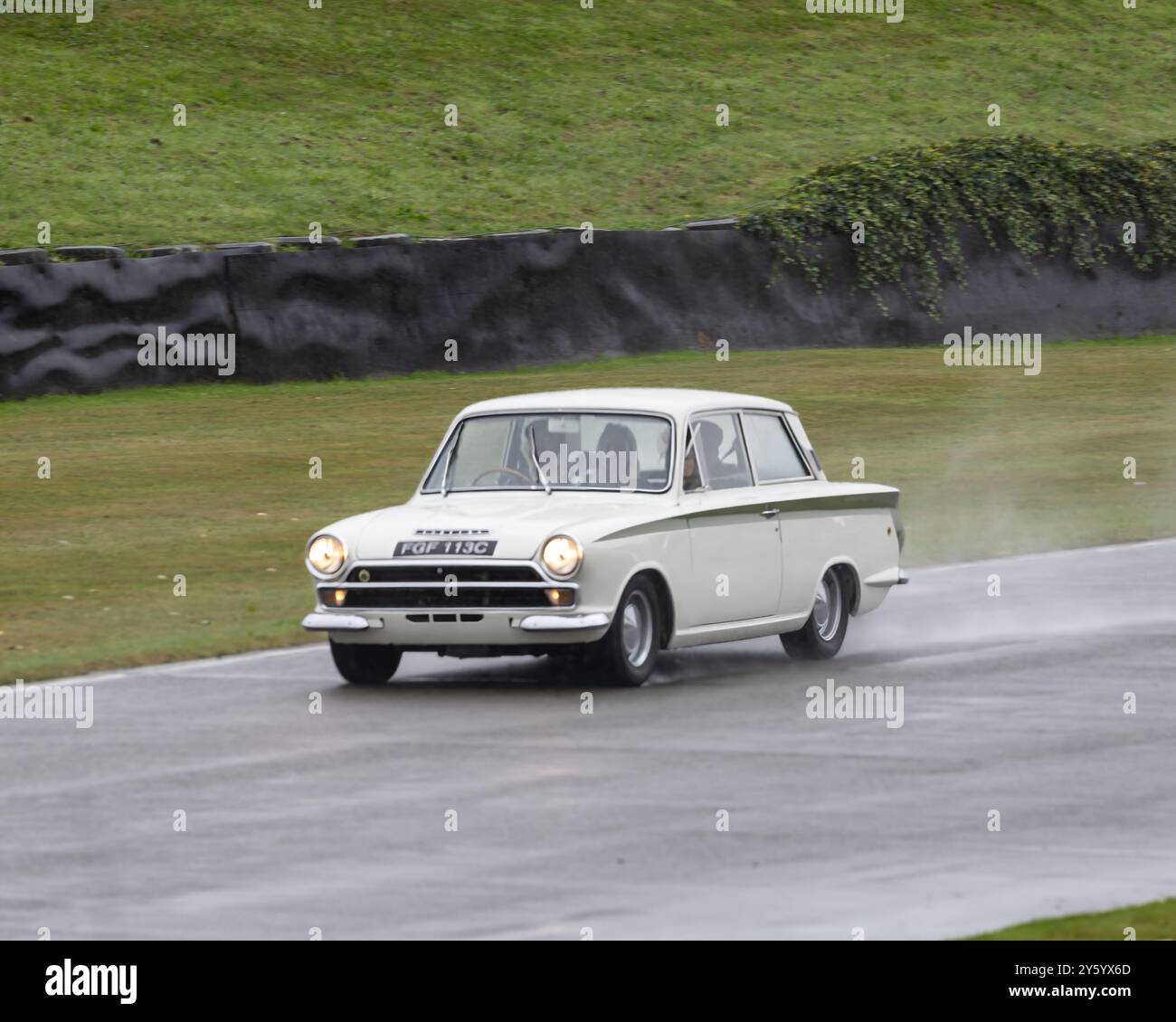A 1965 1600cc Ford Cortina saloon car in the rain at the 2024 Goodwood ...