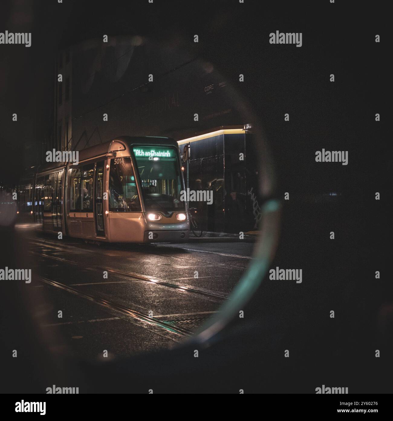 Night view of Dublin with a Luas tram on a rainy evening, seen through ...