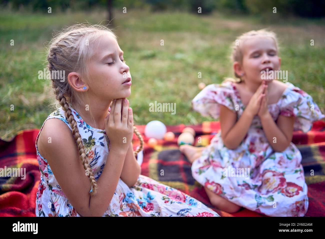 little girls sisters pray to god at easter picnic in the garden Stock ...