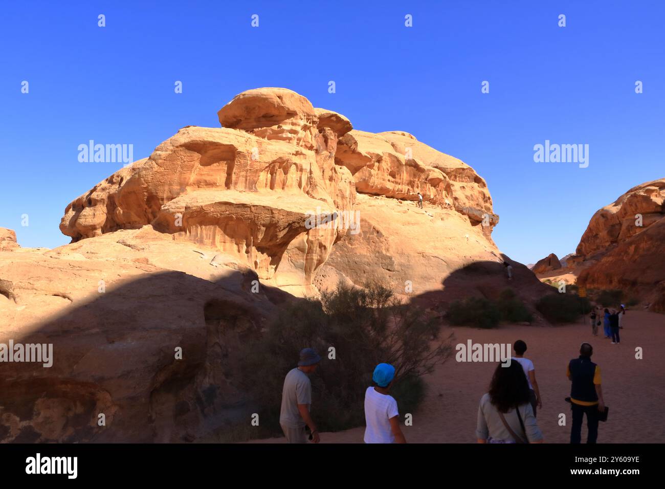 Wadi Rum in Jordan - May 15 2024: people climb up the Jebel Burdah rock ...