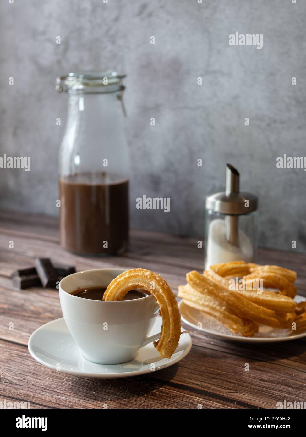 Vertical photo of a hot chocolate with churros. Churro inside the ...