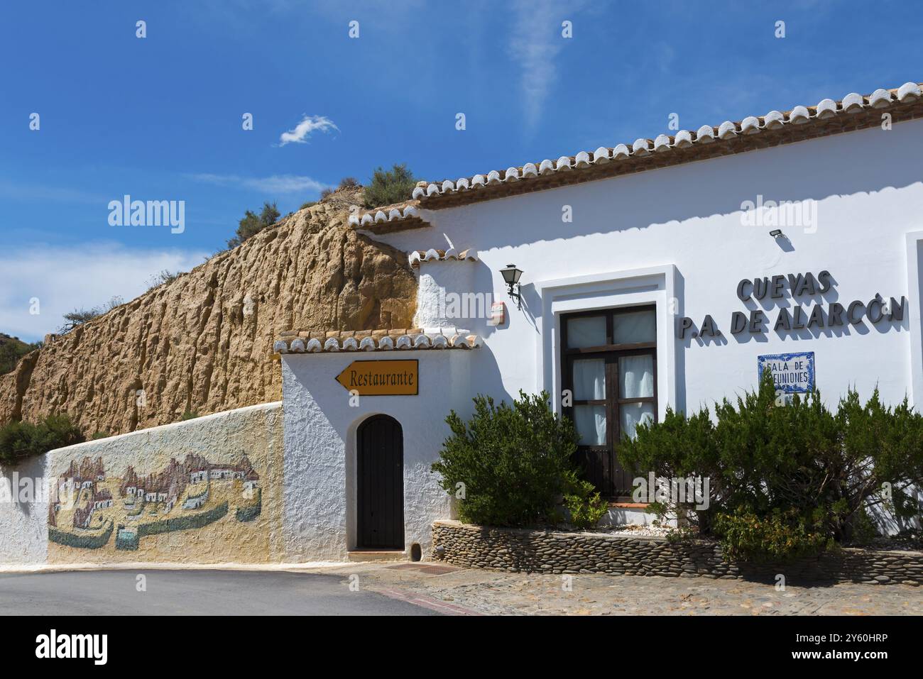 White building with restaurant and painted rock face, surrounded by ...