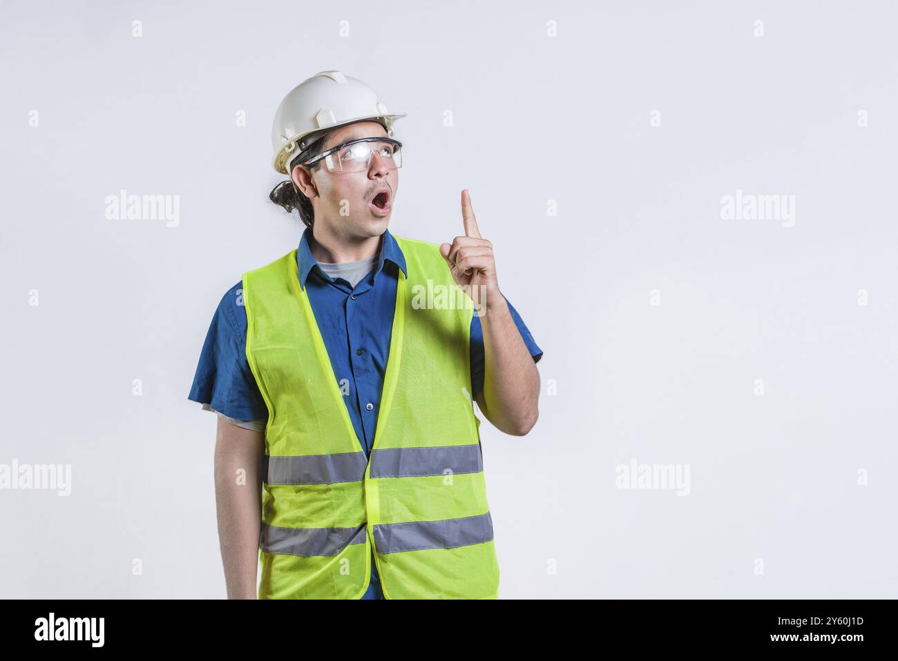 Amazed engineer pointing up isolated. Surprised young architect ...