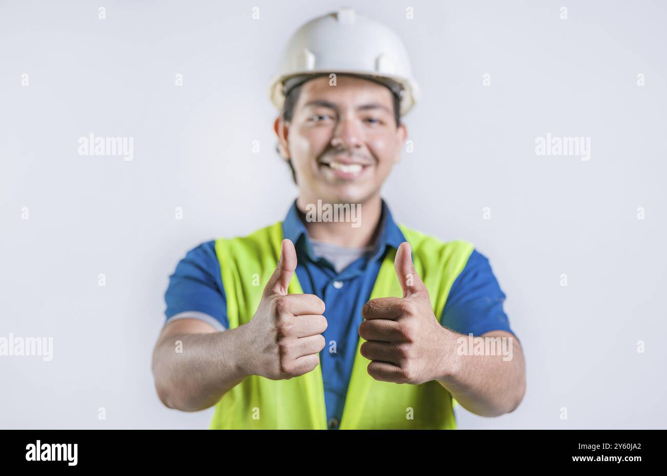 Smiling latin engineer geesturing ok isolated. Positive male engineer ...