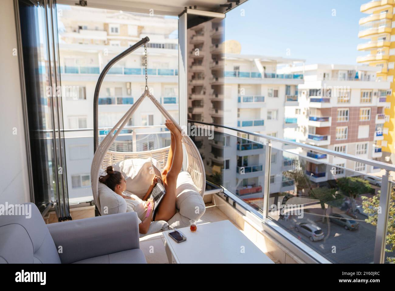 Unwinding and relaxing in a stylish modern balcony hammock while ...