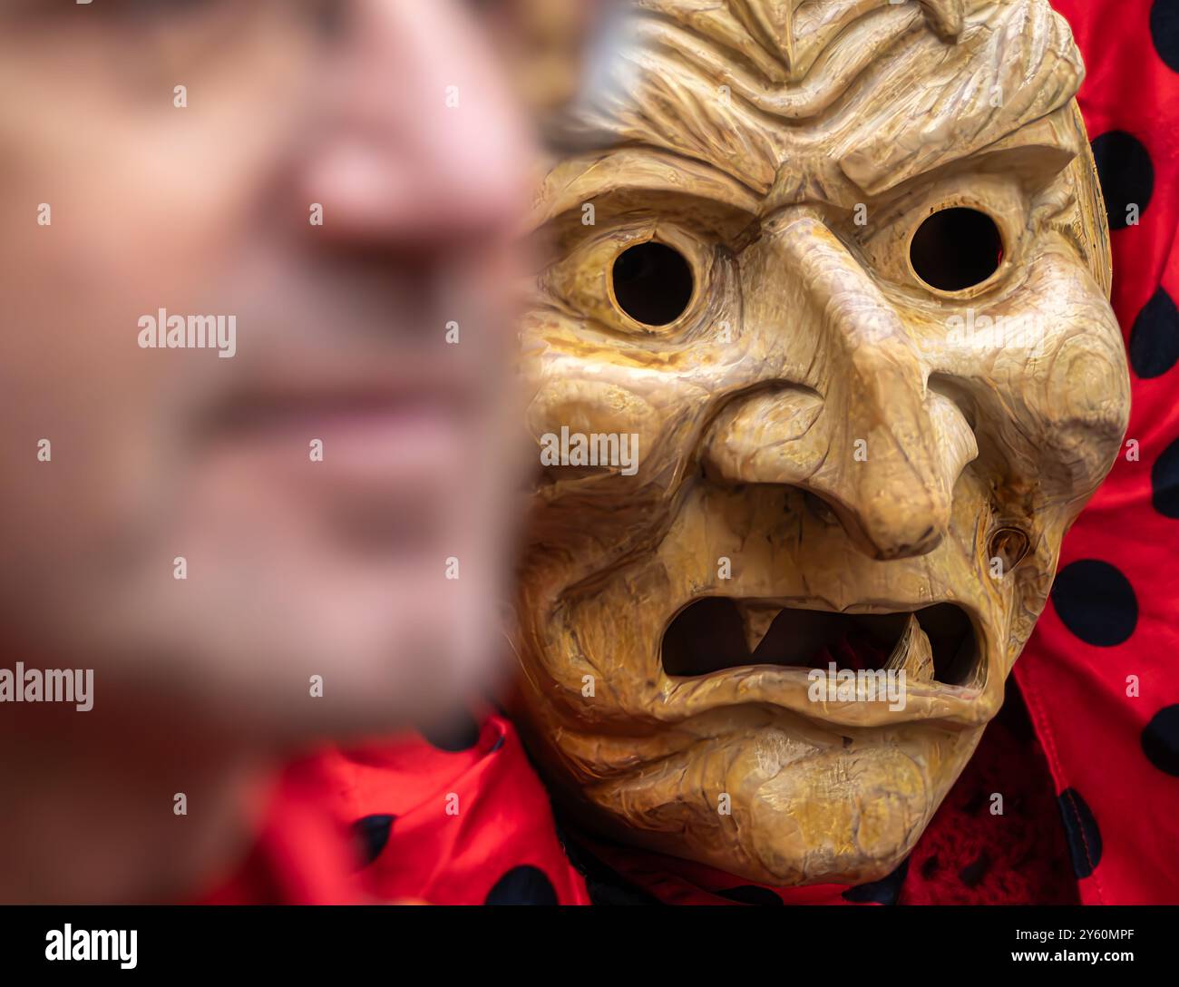 Masquerade. Horror mask in a carnival parade and blurred face of a man ...