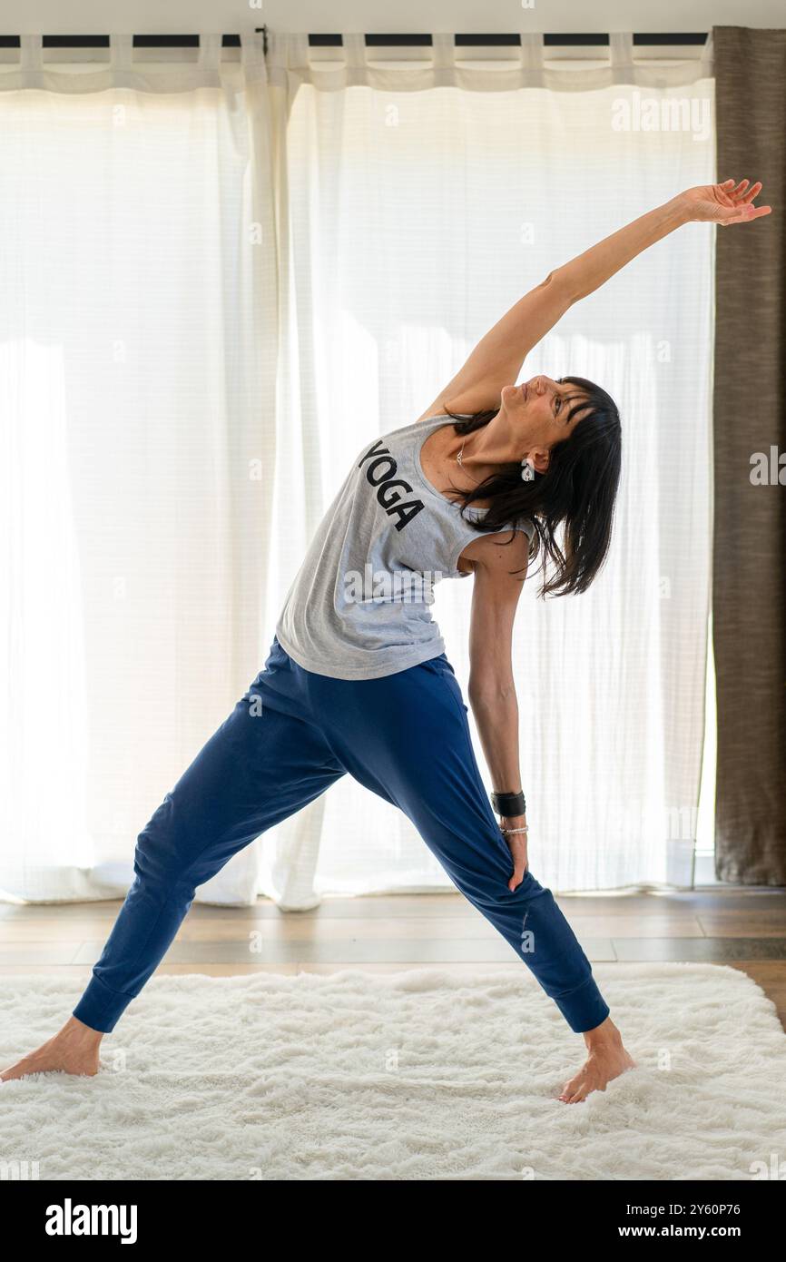 Graceful mid-adult yoga instructor elegantly executing the Reverse ...