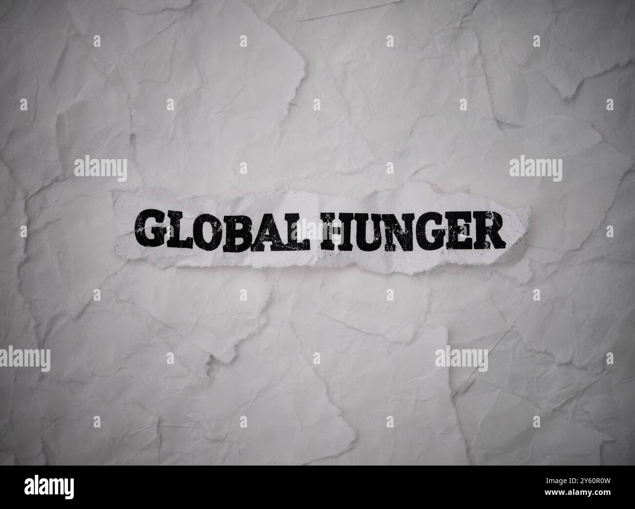 Crumpled piece of paper with words Global Hunger on a torn white paper ...