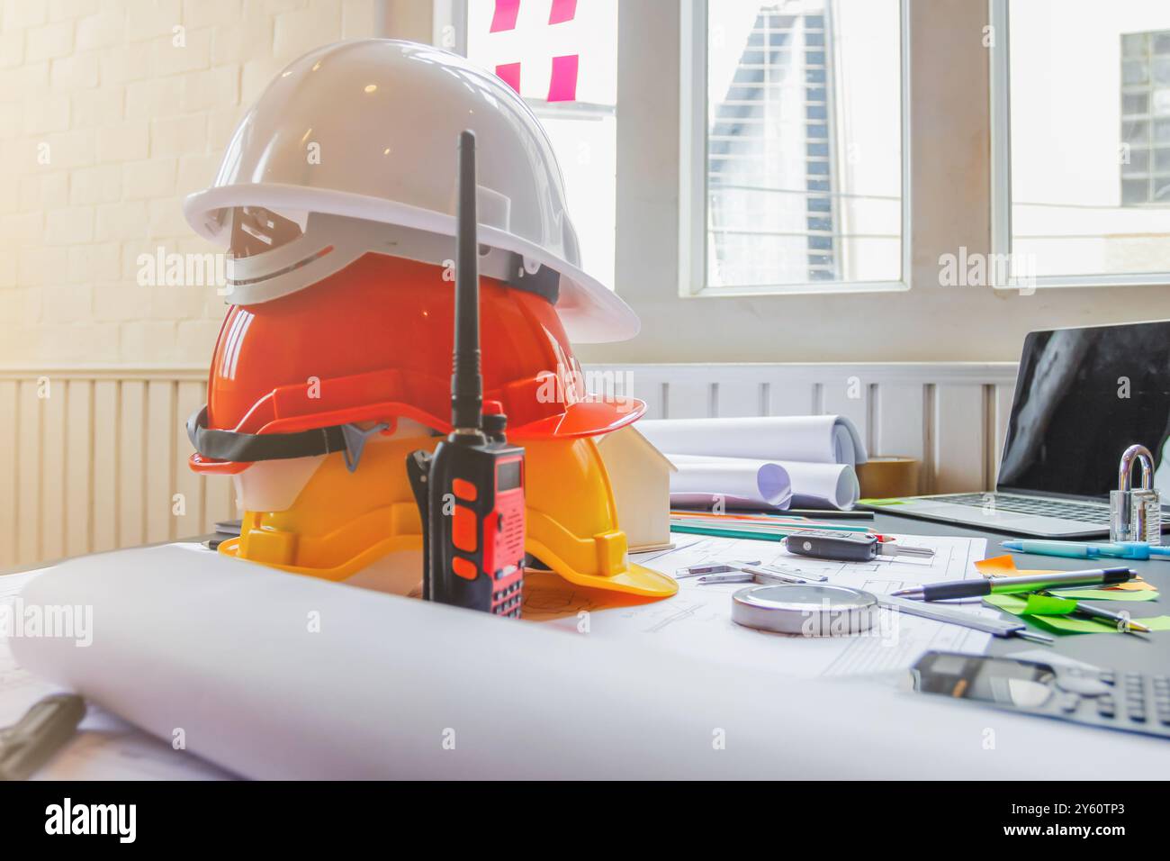 Yellow hard plastic safety helmets sit on work desks in office intended ...