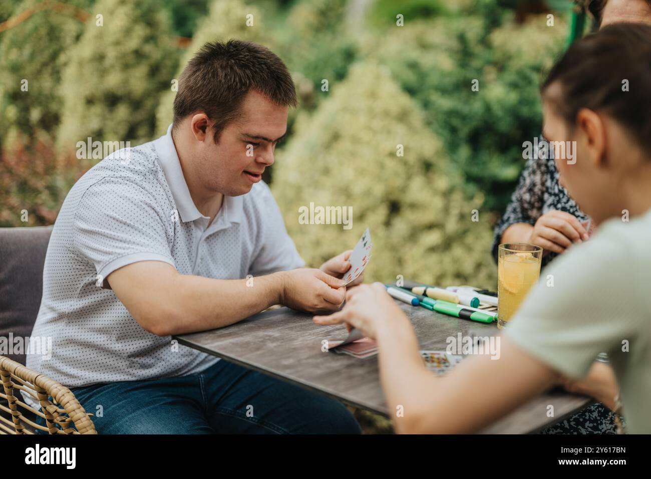 Young man enjoying a friendly card game outdoors Stock Photo - Alamy