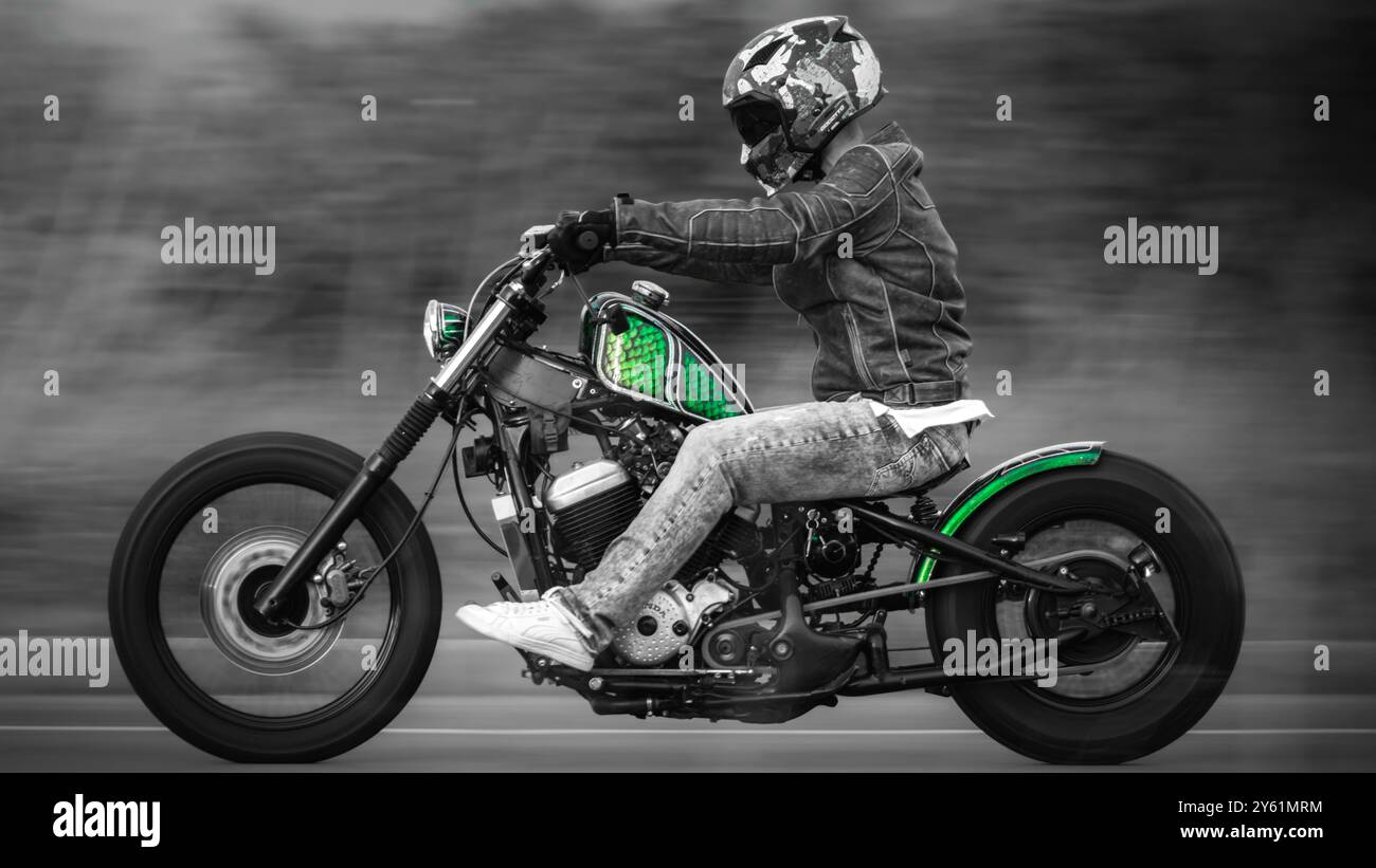 a biker rushes his motorcycle down a road during his road trip Stock ...
