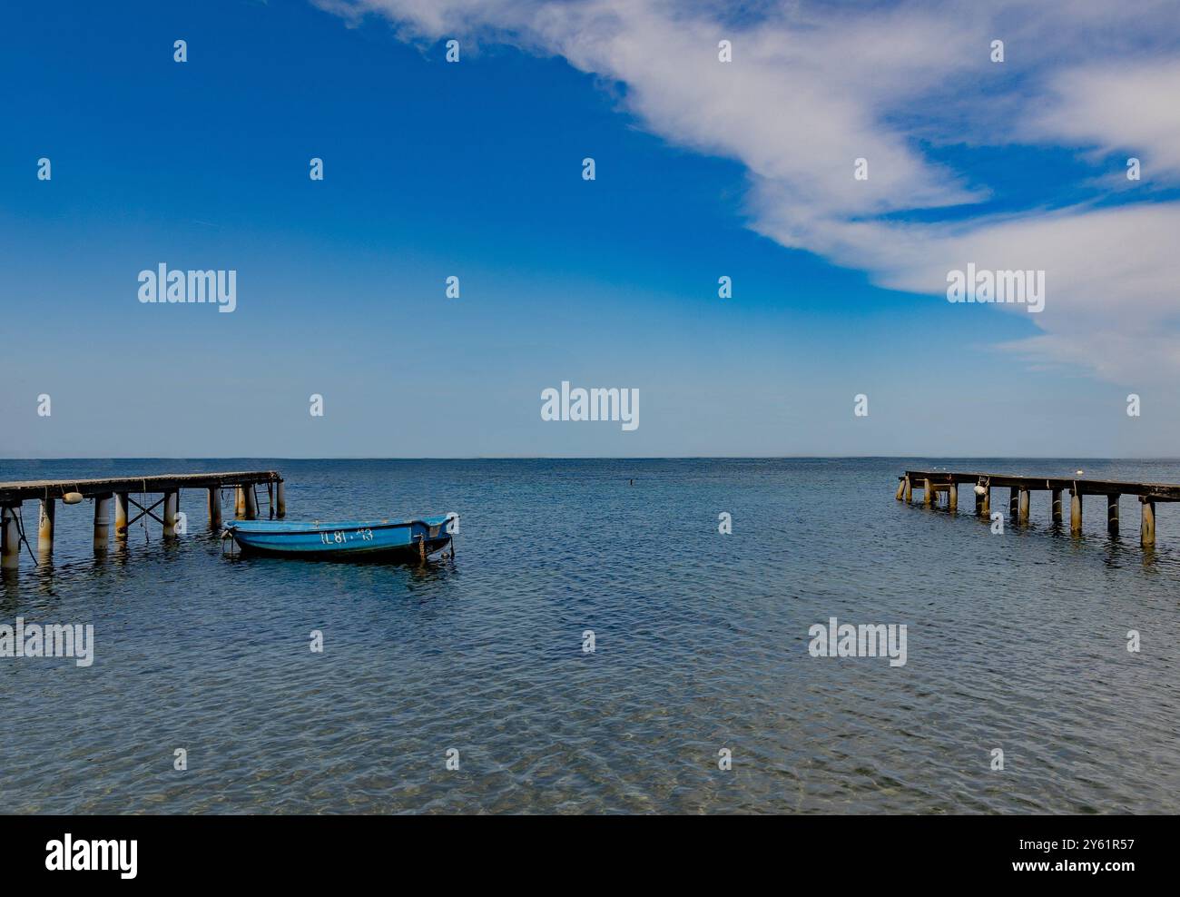 small isolated boat attached to its pontoon, floating on the water in ...