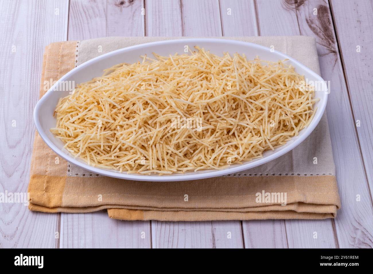 Potato straw or shoestring potato in a plate over wooden table Stock ...