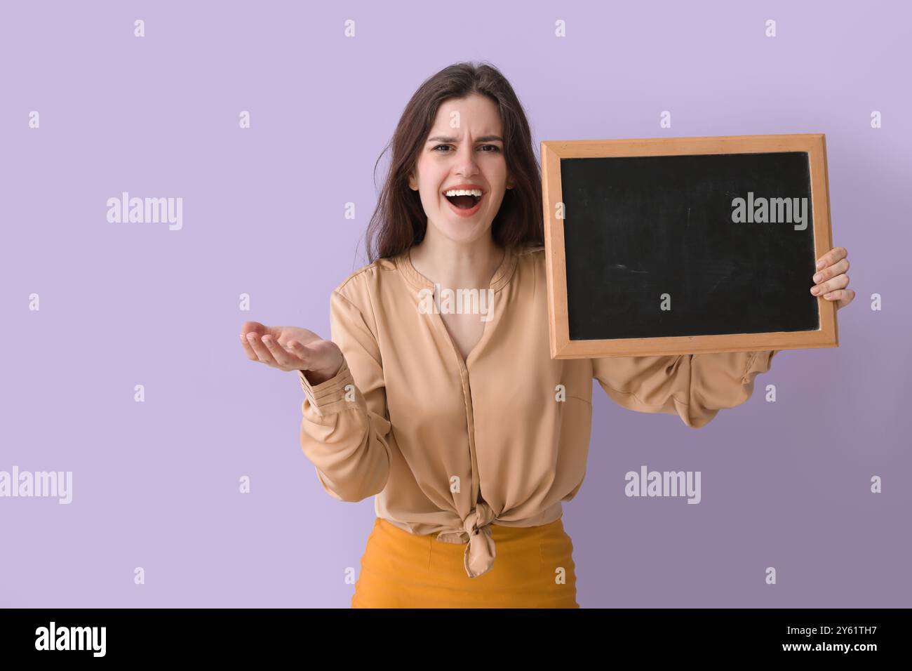 Female teacher with chalkboard on lilac background Stock Photo - Alamy