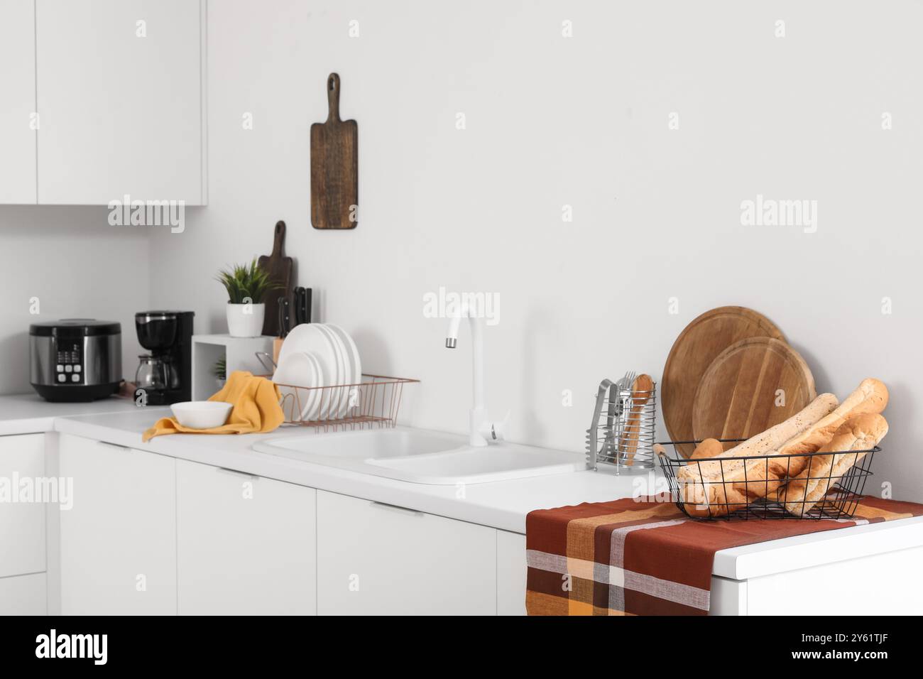 White kitchen counters with coffee machine, multi cooker and utensils ...