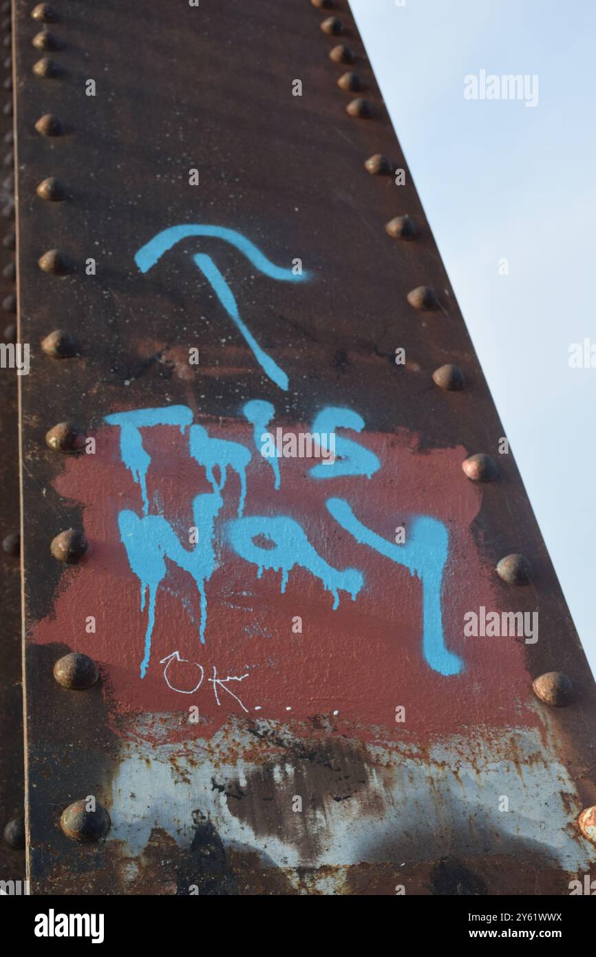 The words this way spray painted over rusted steel beam Stock Photo - Alamy