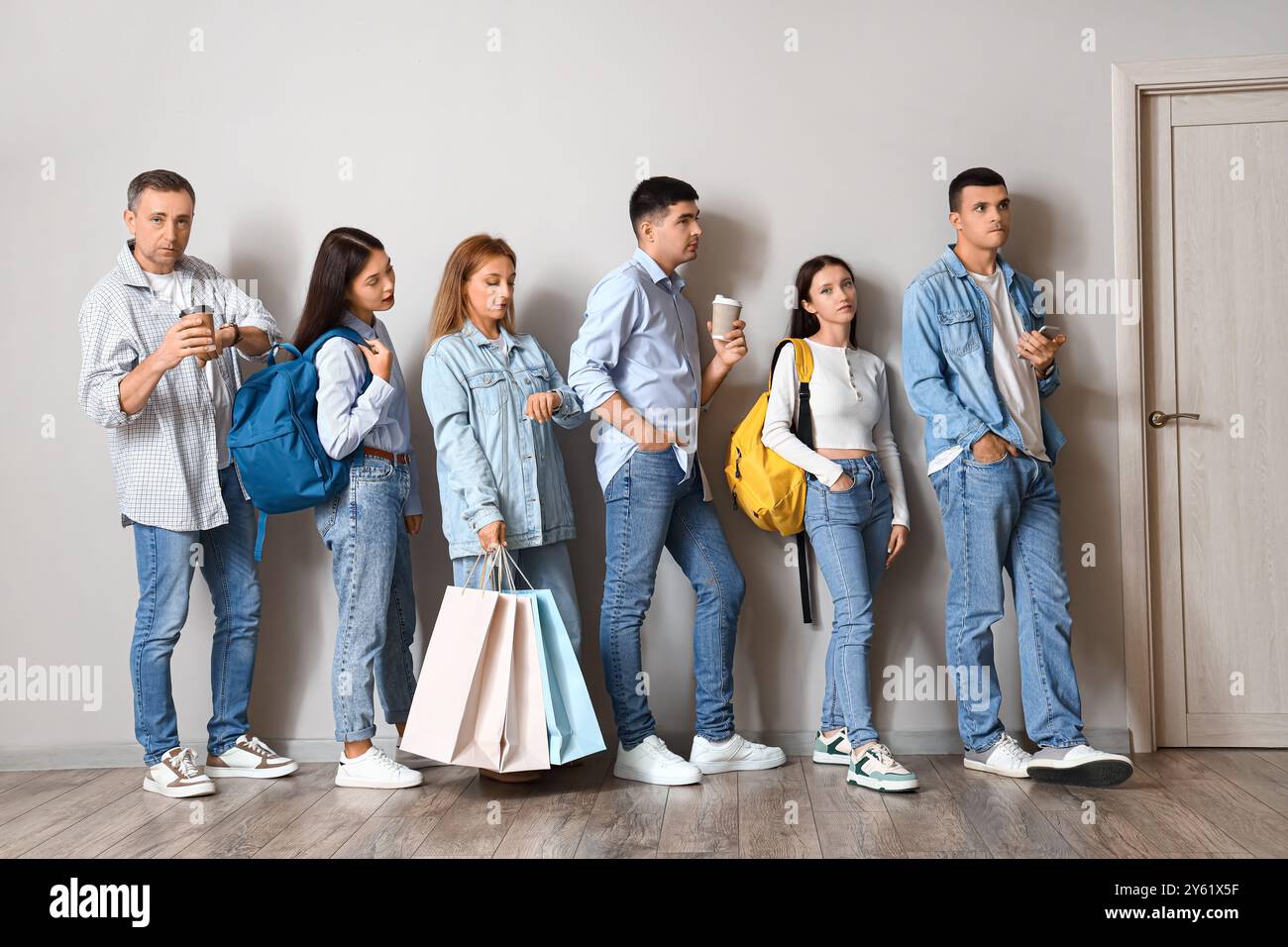 People standing in line near light wall Stock Photo - Alamy