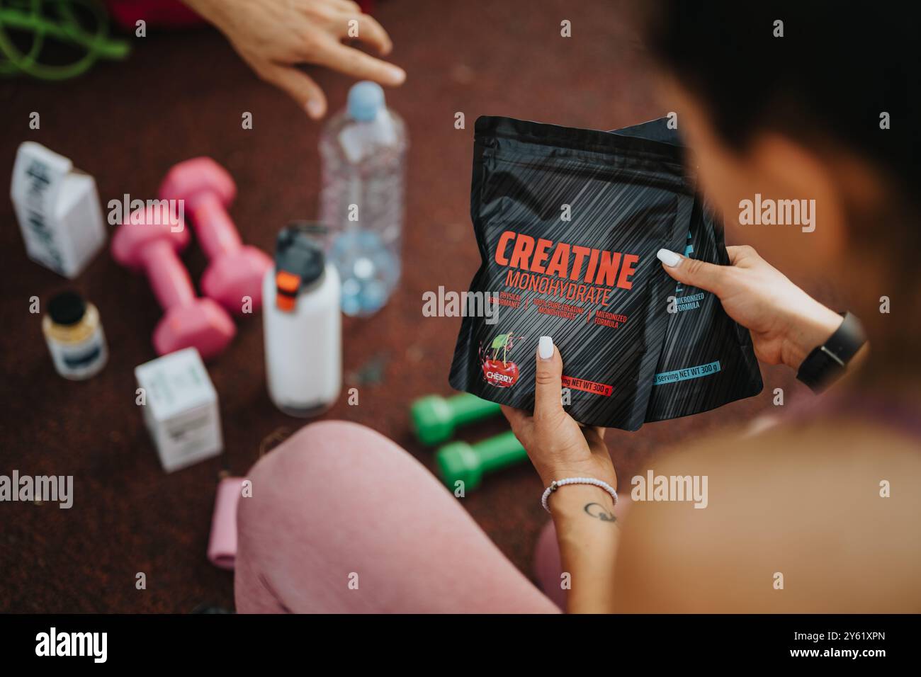 Fitness enthusiast holding creatine supplement packet during outdoor ...