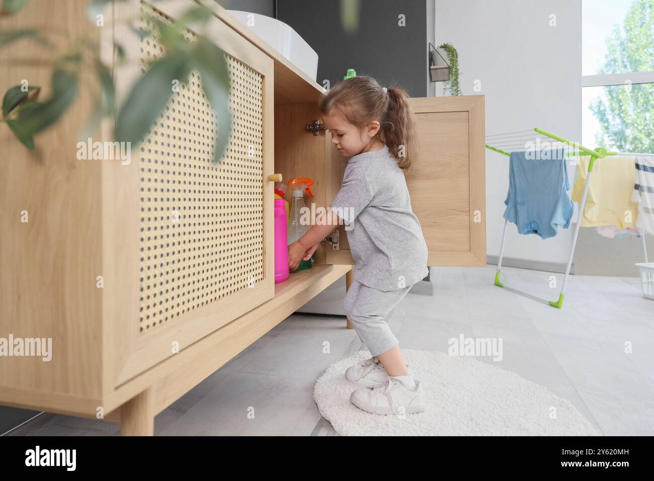 Cute little girl rummaging through drawer in laundry room. Child at ...