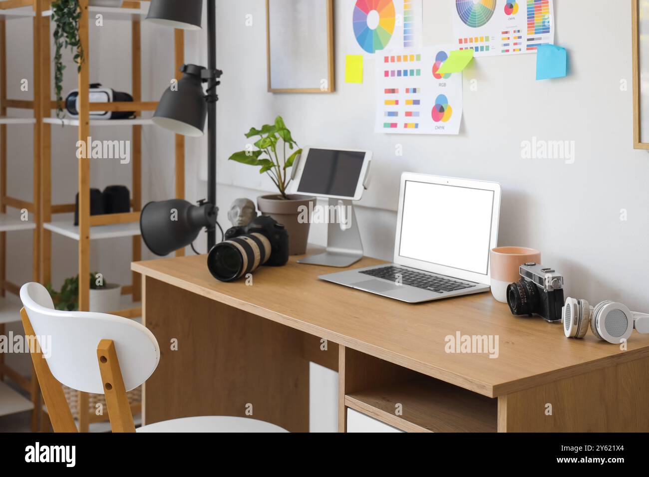 Photographer workplace with laptop, color wheel charts and cameras in ...