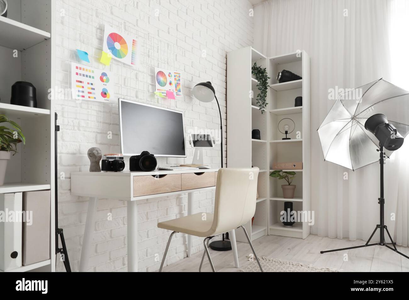 Photographer workplace with computer, color wheel charts and photo ...