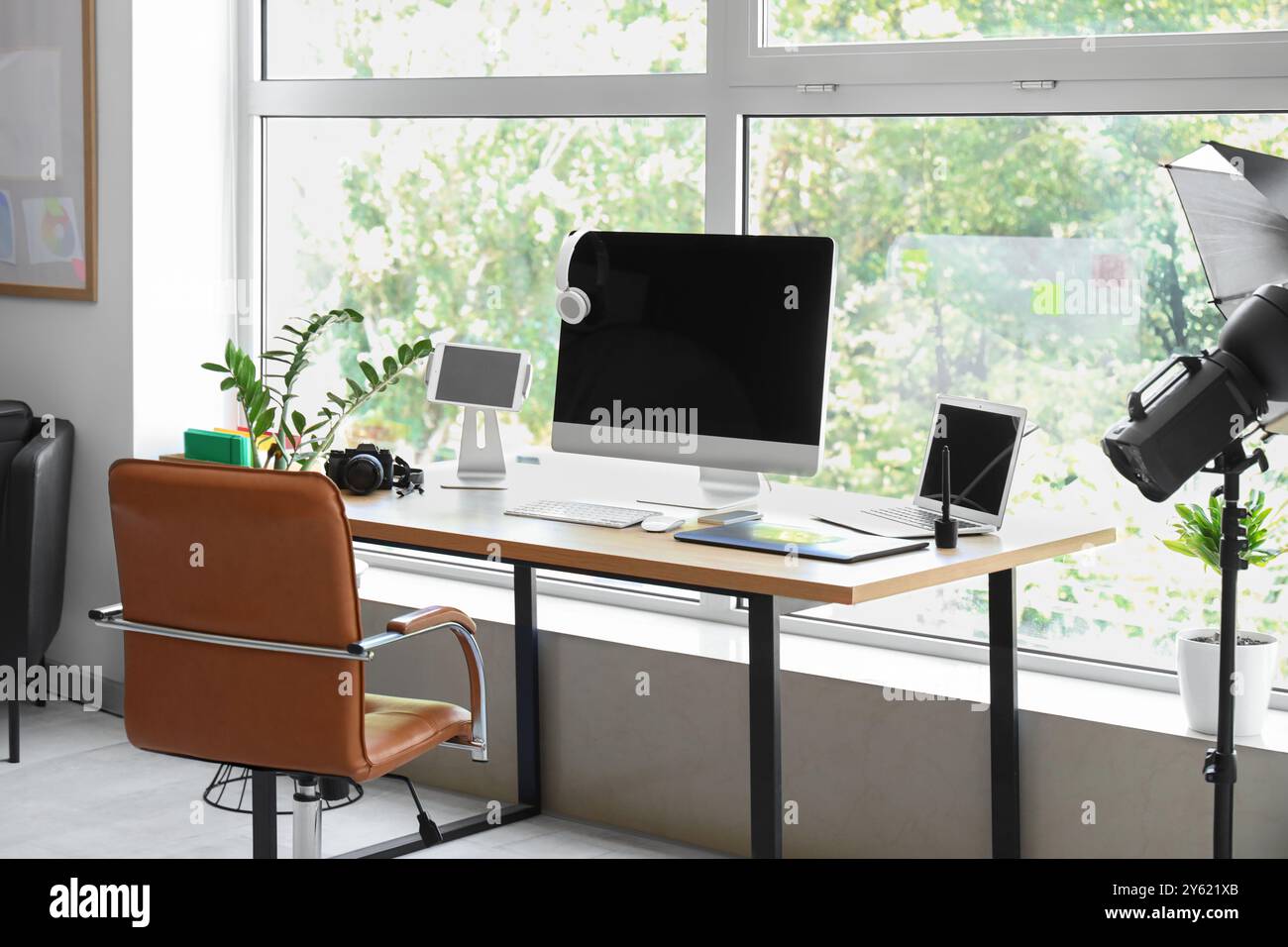 Photographer workplace with computer, laptop and photo camera in modern ...
