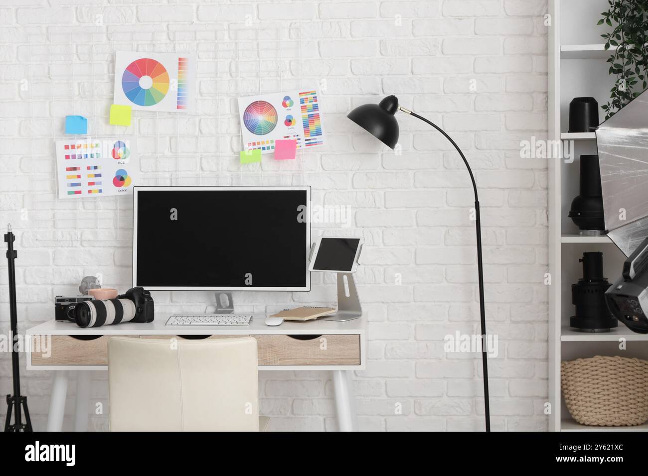 Photographer workplace with computer, color wheel charts and photo ...