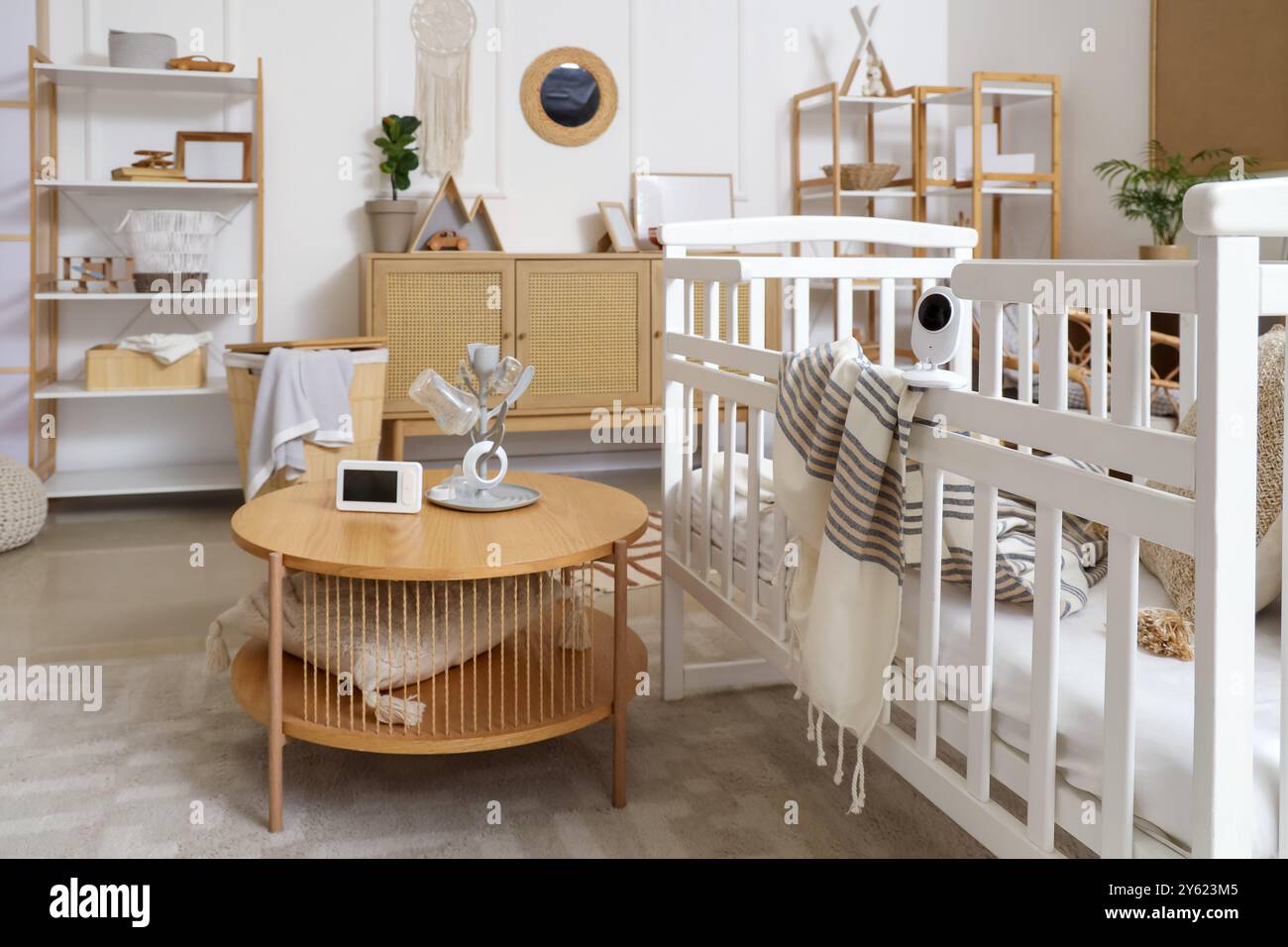 Interior of children's bedroom with crib, shelf units and baby monitor ...