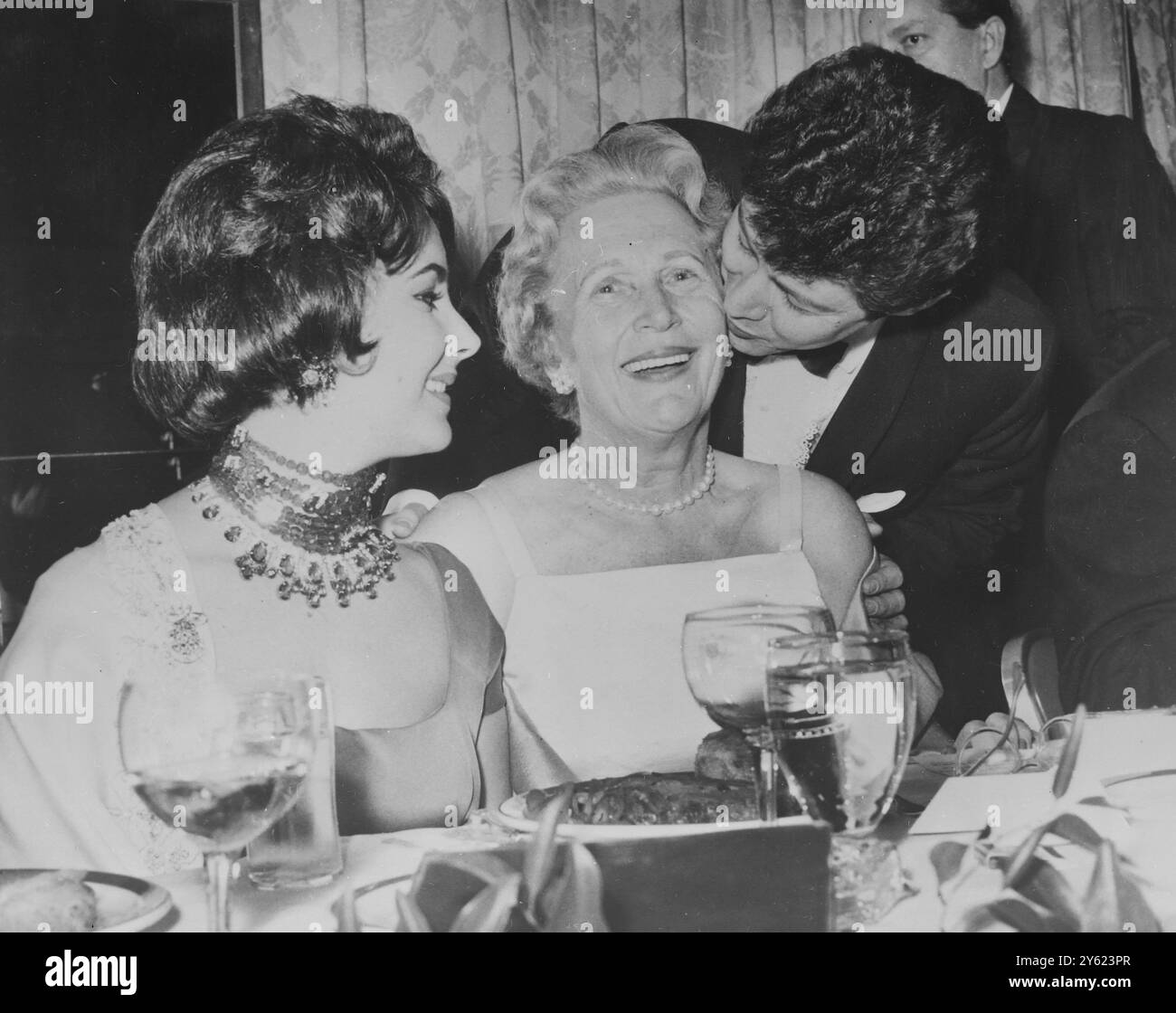 ELIZABETH TAYLOR SMILES AS HER HUSBAND EDDIE FISHER KISSES MRS JENNIE ...