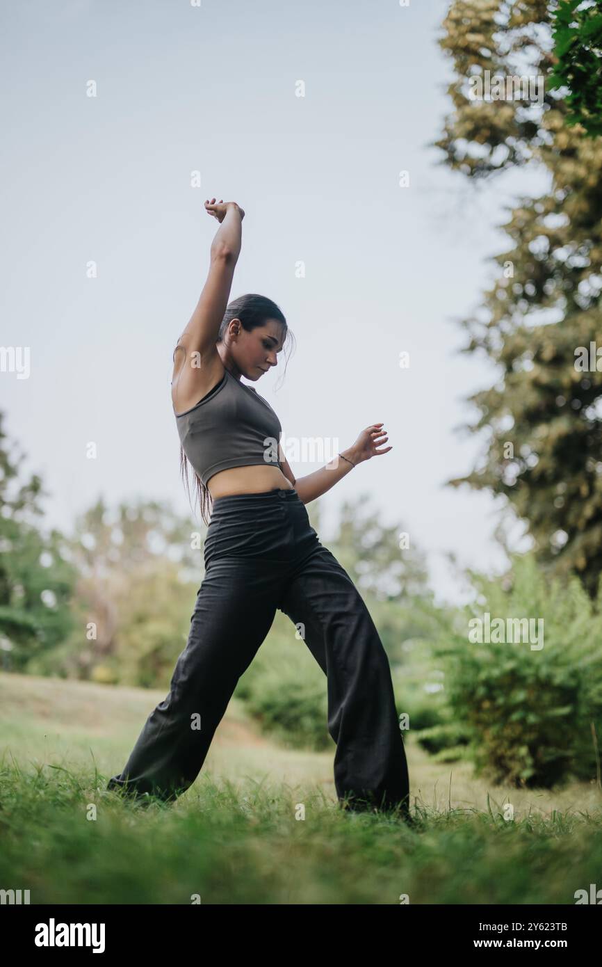 Young woman dancing freely in a serene outdoor park environment Stock ...