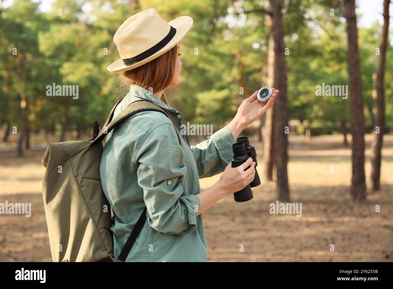 Female traveler with compass and binoculars in forest Stock Photo - Alamy