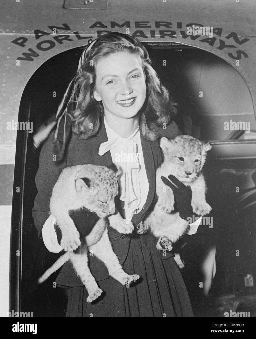 BEAUTY AND THE CUBS Carrying a lion cub under each arm , Miss South ...