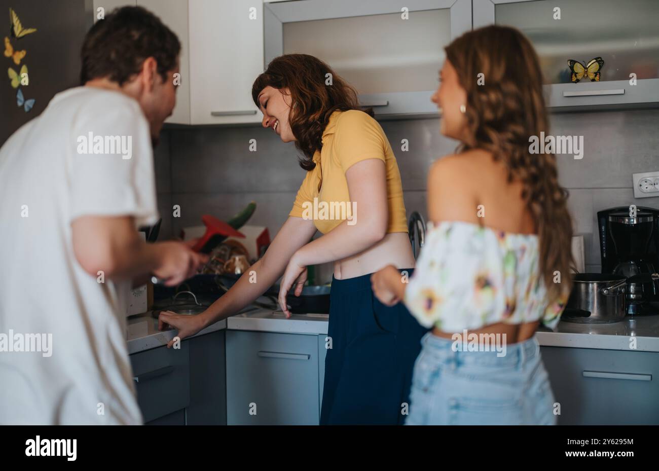Friends laughing and cooking together in a modern kitchen Stock Photo ...