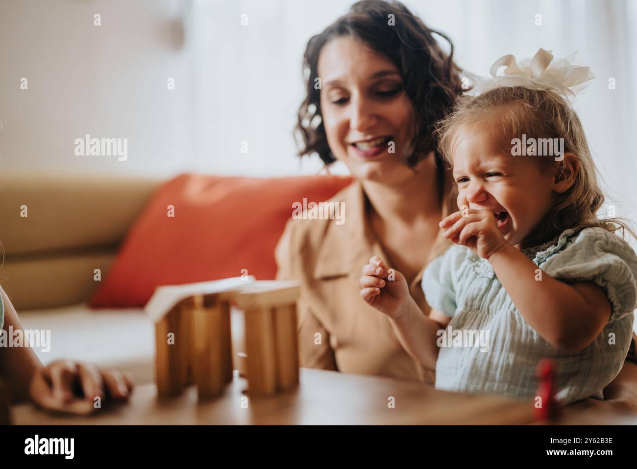 Mother and daughters playing together at home with wooden blocks Stock Photo - Alamy