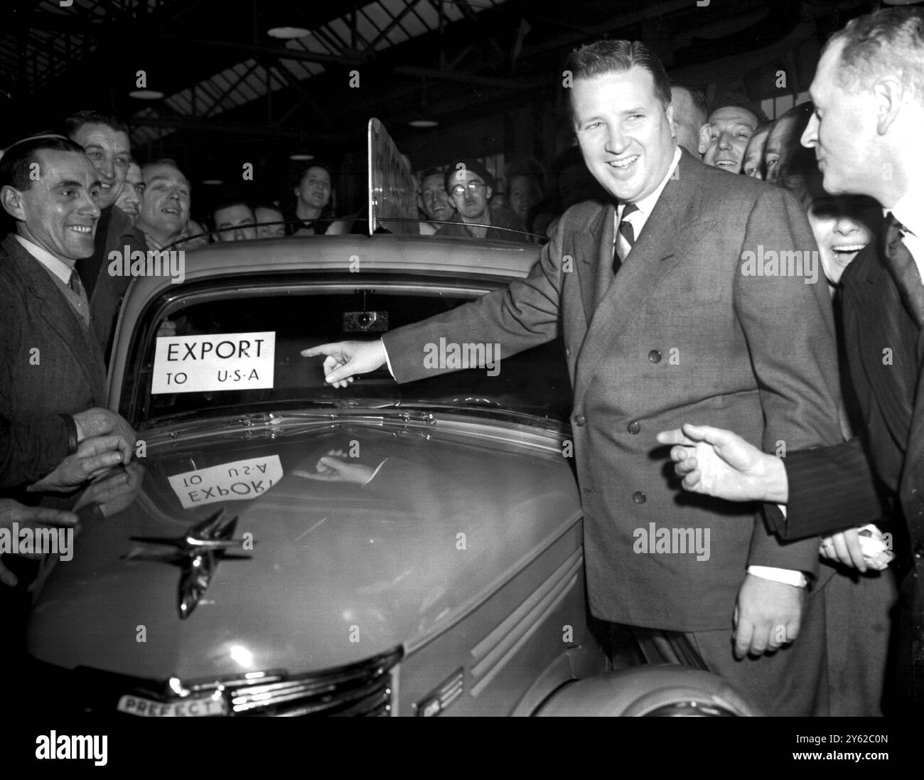Henry Ford II visiting England, pointing to the export mark of the ...