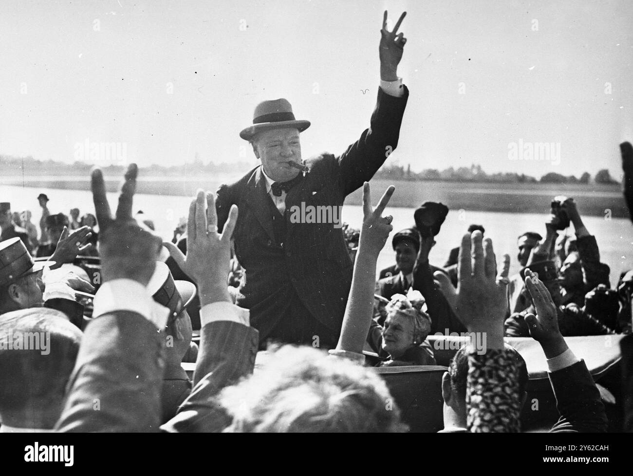 Mr Winston Churchill gives his famous V sign to the cheering crowds at ...