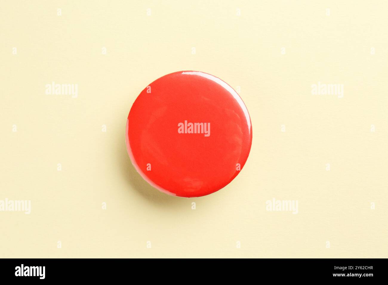 Red button badge on beige background, top view. Mockup for design Stock ...