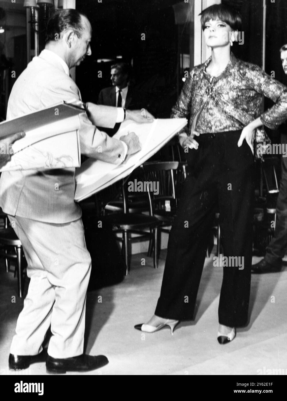 A fashion artist sketches the details of a new trouser ensemble in the ...