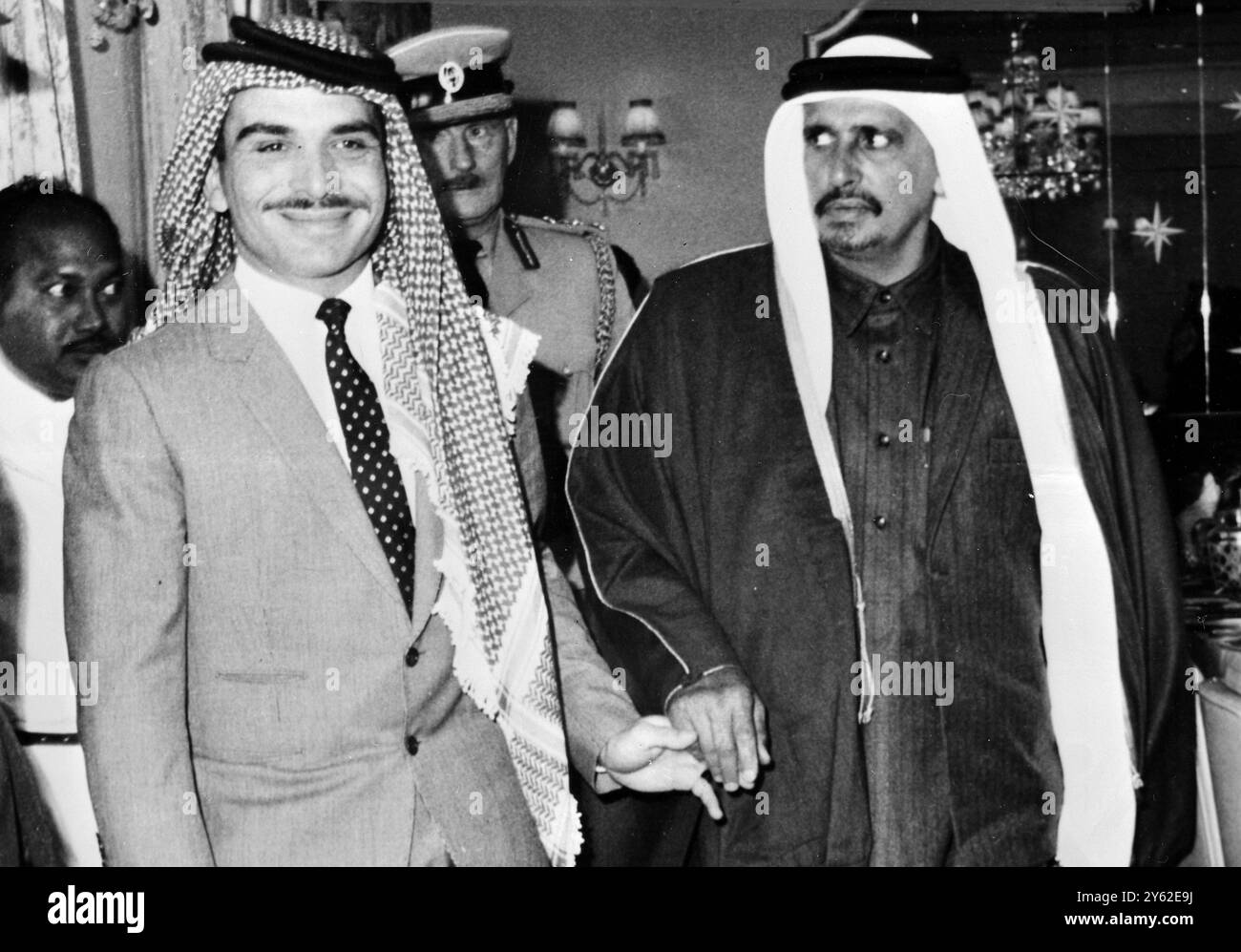 Qatar: Visiting King Hussein of Jordan (left) holds the hand of the ...