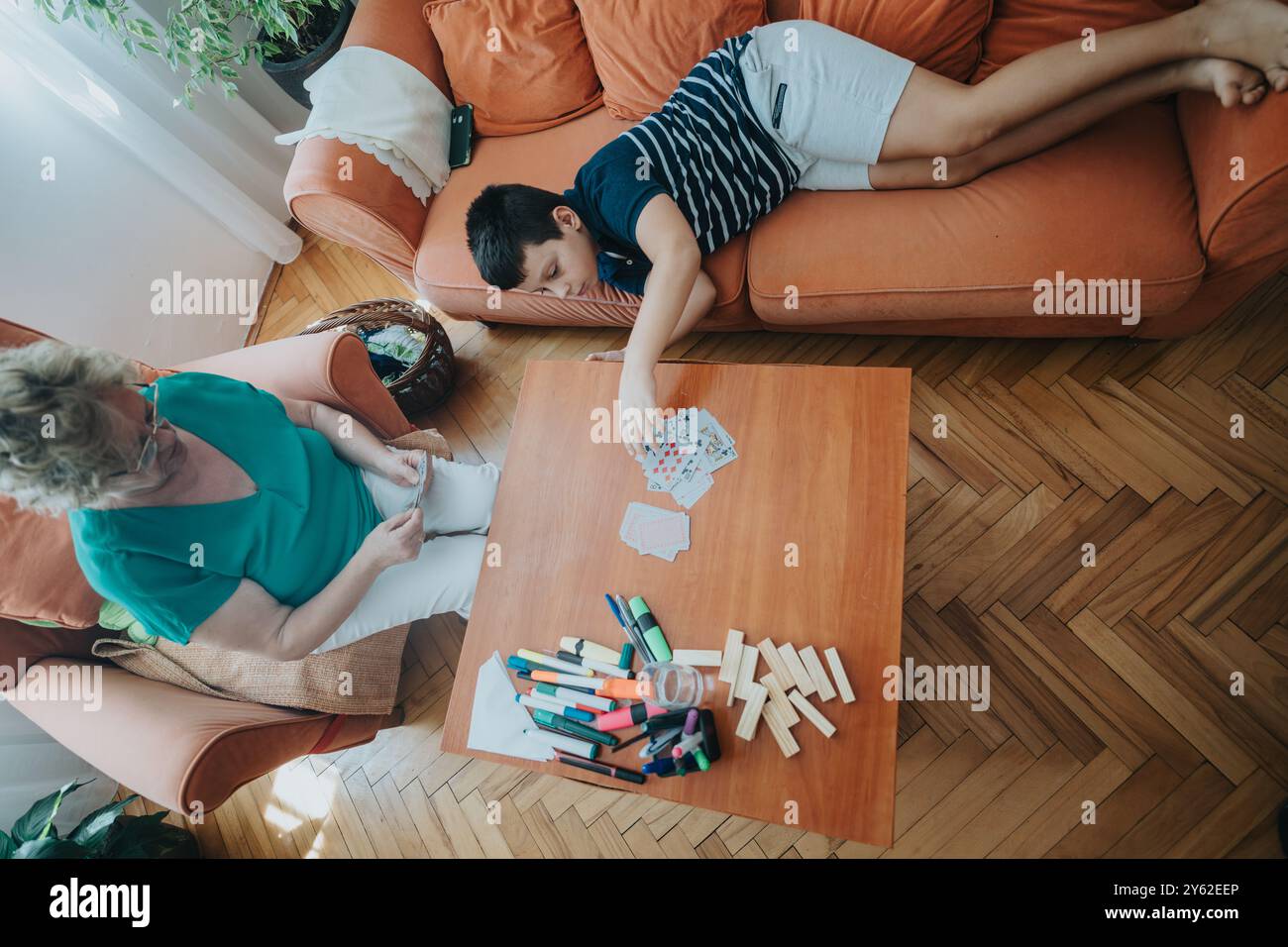 Grandmother and grandson enjoying a playful card game together at home ...