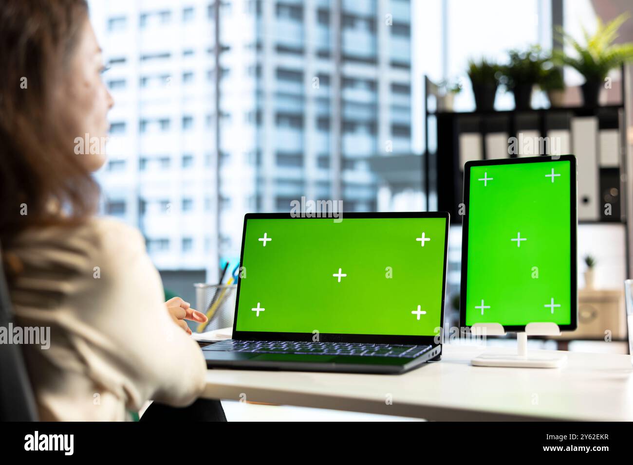 Business director working in her own office with green screen, looking ...