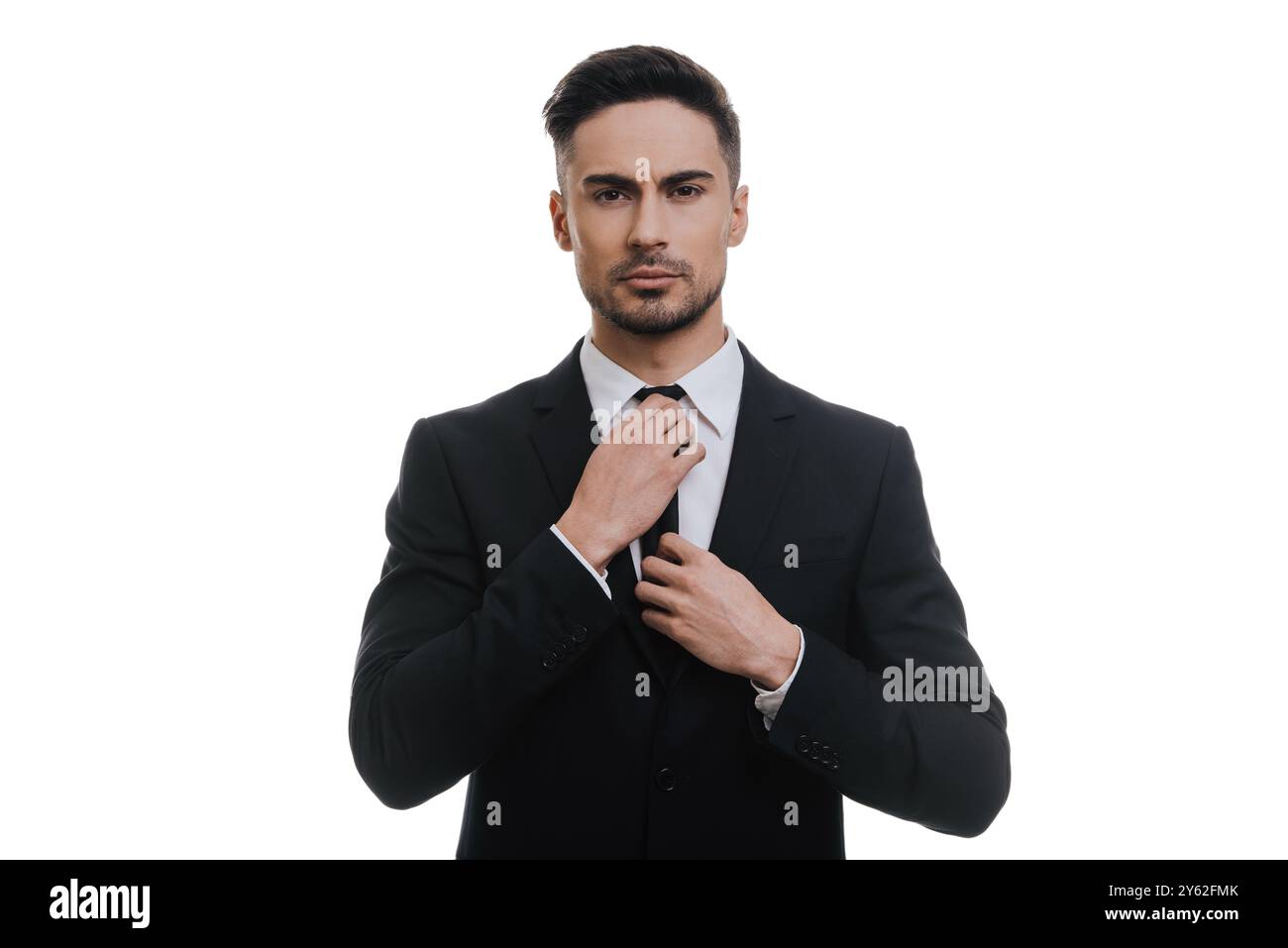 Always perfect. Handsome young man in full suit adjusting his necktie ...