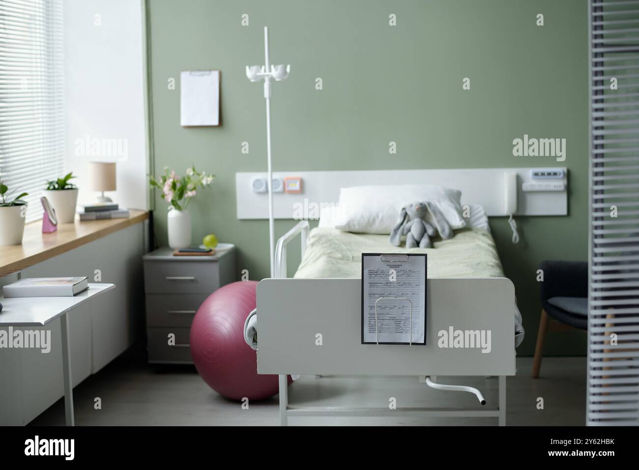 Light-filled hospital room featuring medical equipment, bed with ...